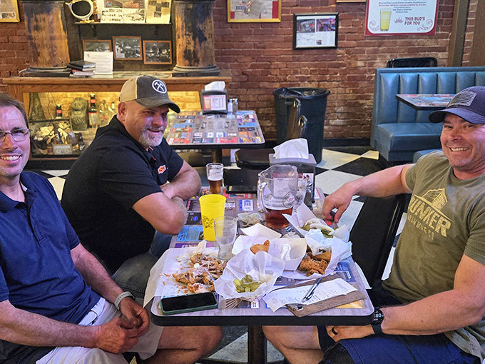 Three friends enjoying the communal experience of Eischen's. Nothing brings people together like tearing into fried chicken and raising a glass.