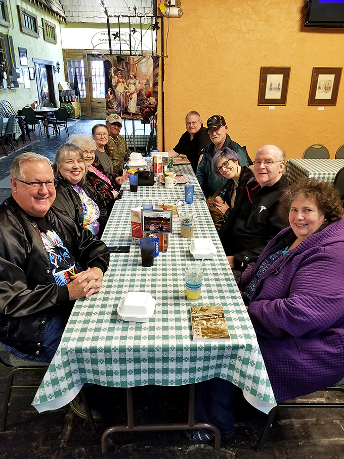 A gathering of friends around a checkered tablecloth proves that breaking bread together never goes out of style at this community hub.