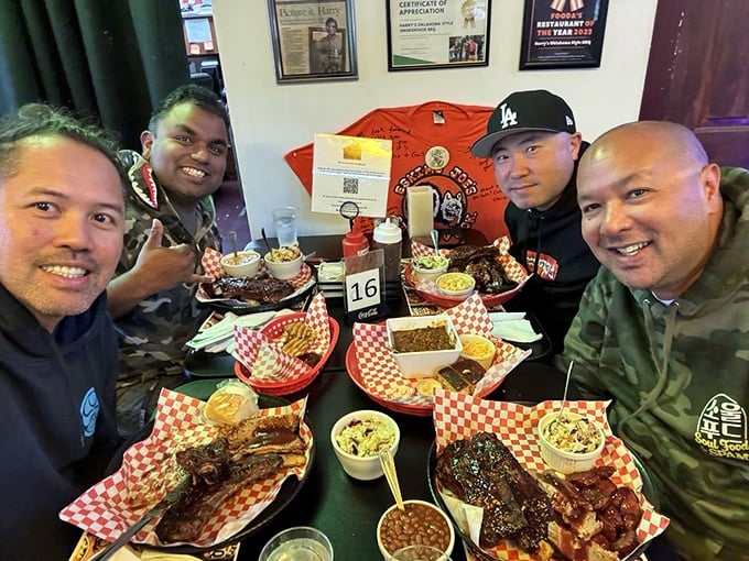Happy diners surrounded by a feast fit for royalty. Four plates, countless sides, and the satisfied smiles that come from BBQ done right.