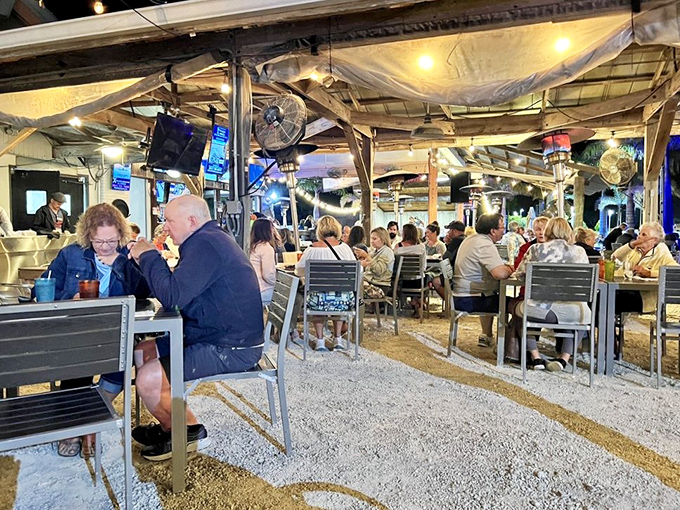 As evening falls, the dining area transforms into a twinkling gathering spot where strangers become friends over shared plates and island stories.
