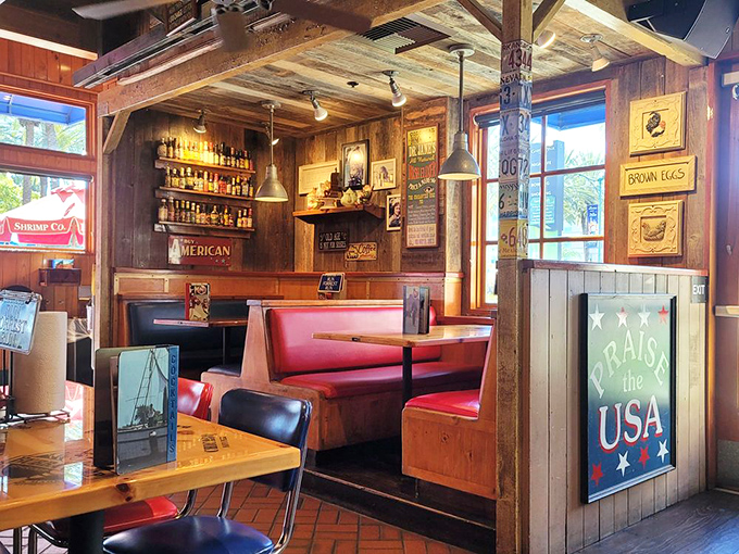 Red vinyl booths nestled among wooden walls create cozy dining nooks where conversations flow as easily as the drinks from the nearby bar.
