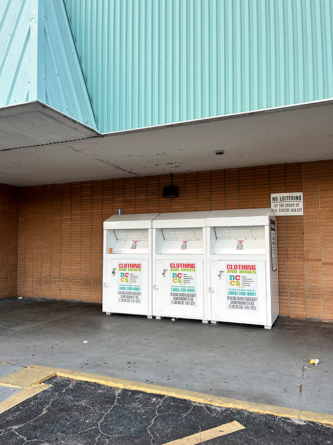 Donation bins stand ready to receive yesterday's fashions, completing the circle of thrift life outside the store's brick facade.