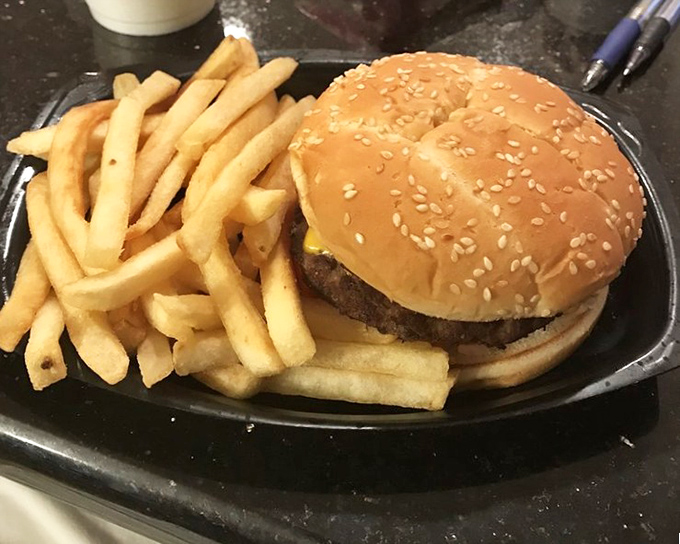A double cheeseburger and fries on a black tray&mdash;proof that sometimes the simplest pleasures deliver the most profound satisfaction.