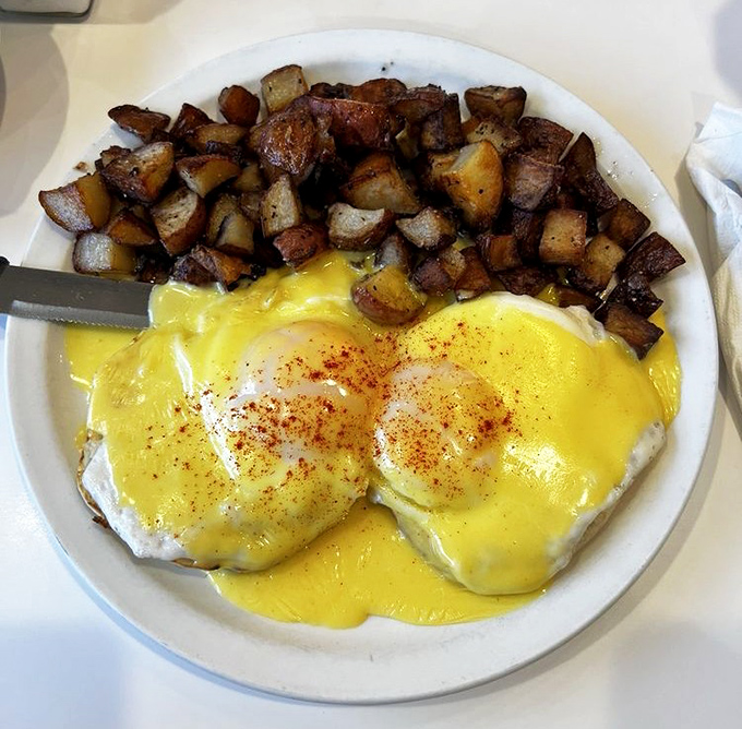 Eggs Benedict that would make a French chef weep with joy. Those perfectly crispy potatoes are the supporting actors who deserve their own Oscar.