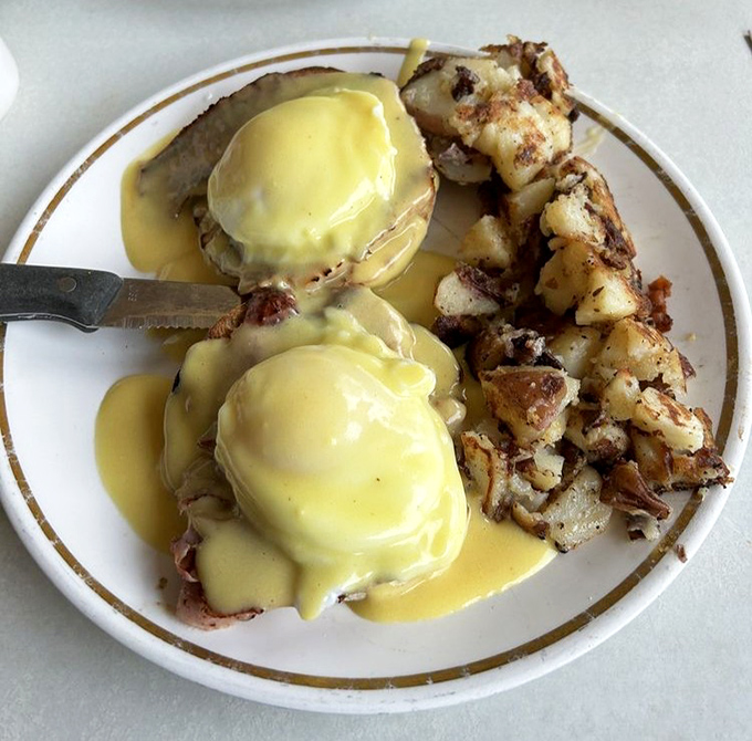 Eggs Benedict executed with military precision. That hollandaise sauce cascading down like a yellow waterfall of happiness deserves its own Instagram account.