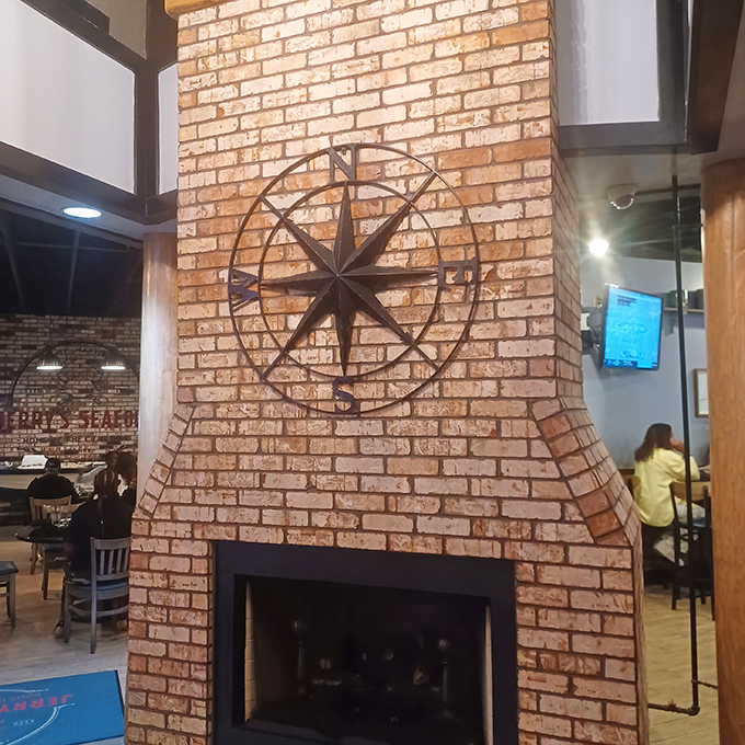 The brick fireplace with nautical compass art anchors the dining room with cozy maritime charm. A North Star for seafood lovers navigating Maryland's dining scene.