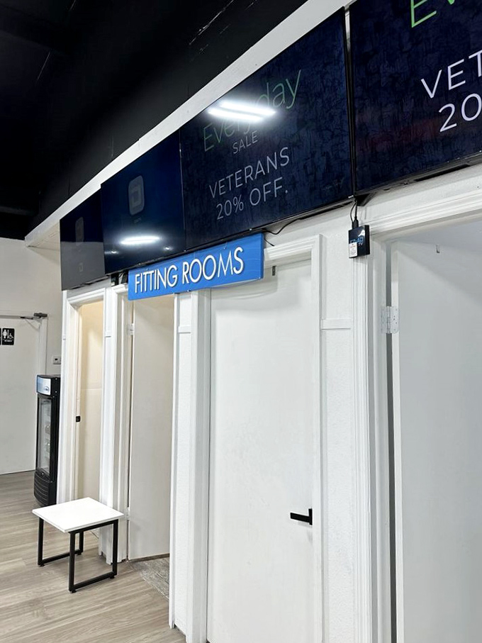 Even the fitting rooms at Tampa Thrift maintain a clean, organized appearance, with special discounts for veterans advertised above.