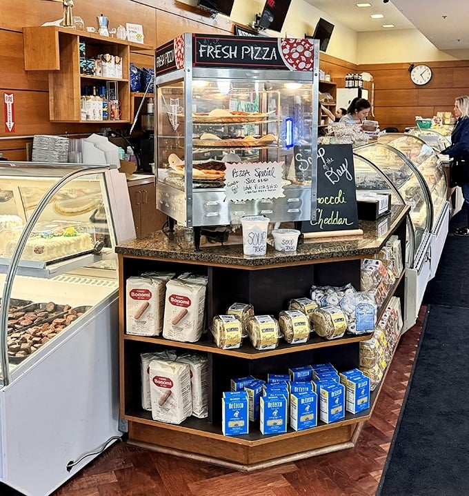 Fresh pizza waiting patiently behind glass, while Italian pantry staples stand guard below. This corner of Corbo's whispers, "Tonight's dinner could be amazing."
