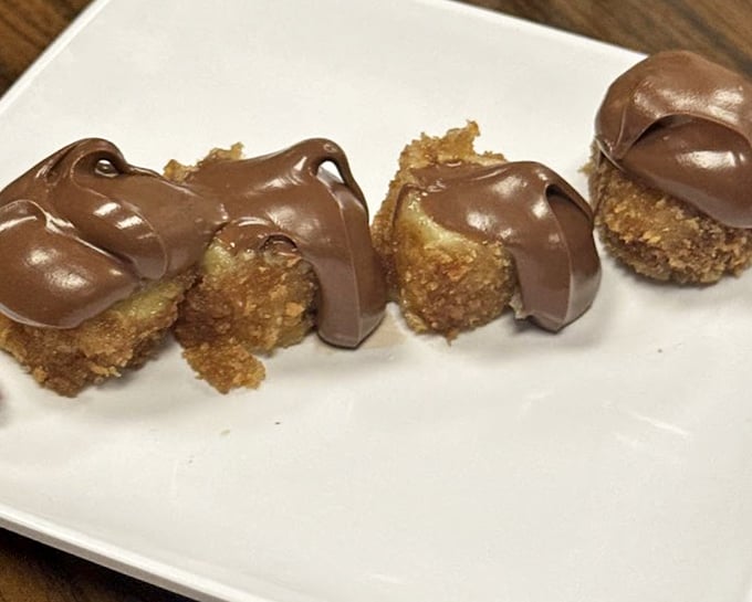 Fried banana with Nutella drizzle &ndash; where tropical fruit meets European chocolate in a dessert that should require a passport.