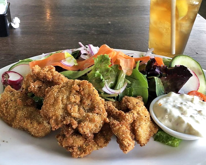 Cornmeal-crusted oysters nestled beside fresh greens&mdash;proof that "fried" and "light" can happily coexist on the same delicious plate.