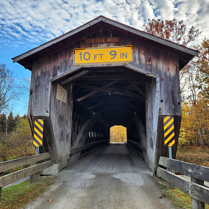 The entrance beckons like a portal to simpler times. That height warning is both practical advice and a challenge to modern vehicles.