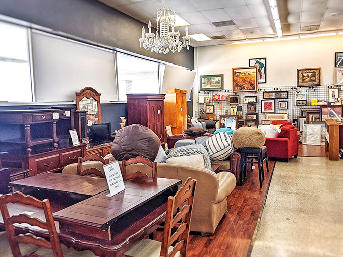 A chandelier hangs majestically above an eclectic furniture showroom, proving that secondhand elegance is still elegance, just with better stories.