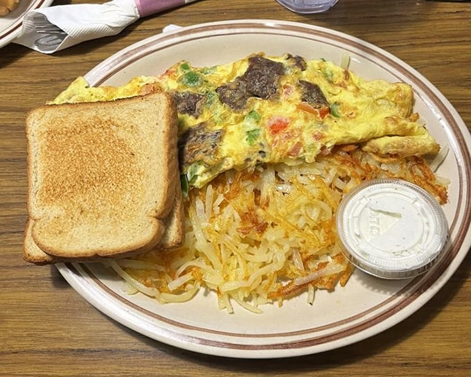 An omelet that refuses to be confined to breakfast hours. Those crispy hash browns are the supporting actors who steal the scene.