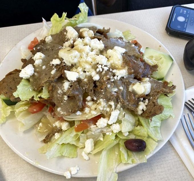 A Greek salad that respects tradition: crisp lettuce, generous feta, and what appears to be gyro meat playing the role of protein hero.
