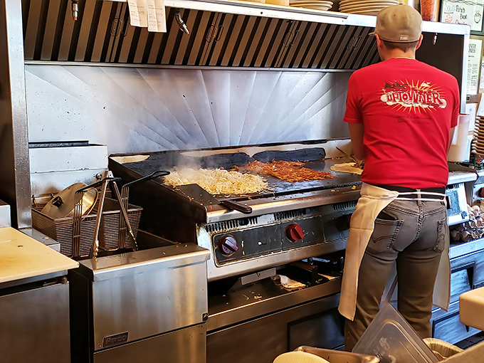 Breakfast alchemy in action&mdash;where potatoes transform into golden hashbrowns under the watchful eye of a griddle master.