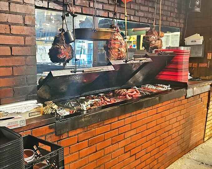The brick pit where briskets transform into legends, one slow-smoked masterpiece at a time, visible right from the dining area.