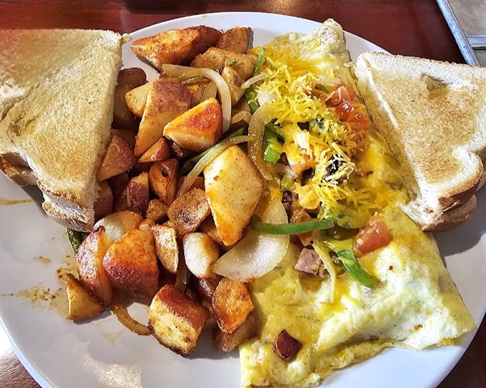 An omelet that's having a party and invited all your favorite ingredients, with home fries that crashed the celebration.