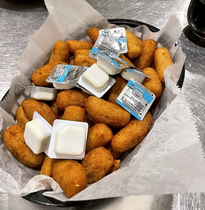 Golden hush puppies nestled in paper&mdash;crispy outside, tender inside. These aren't just side dishes; they're the supporting actors that steal the show.