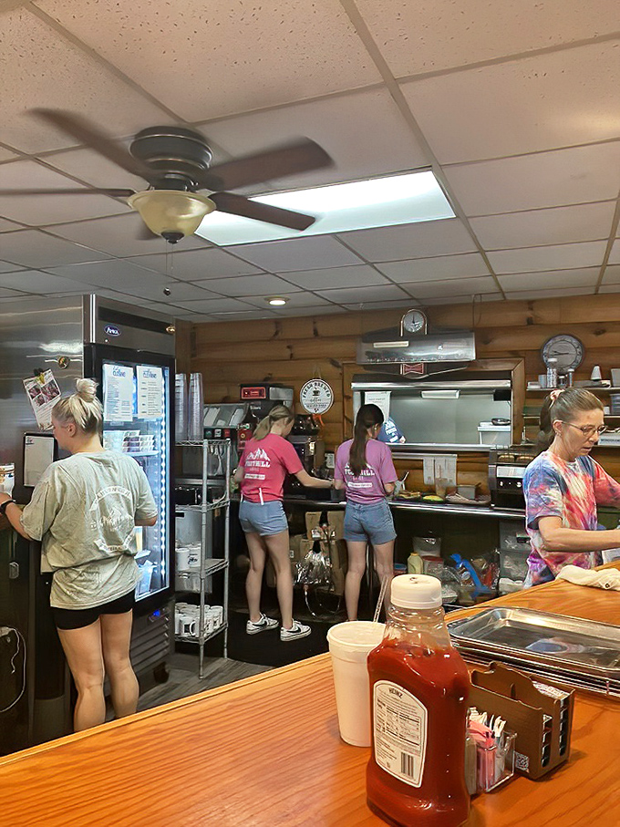 A glimpse into the kitchen reveals the breakfast ballet &ndash; staff moving with practiced precision while ketchup bottles stand guard in the foreground.