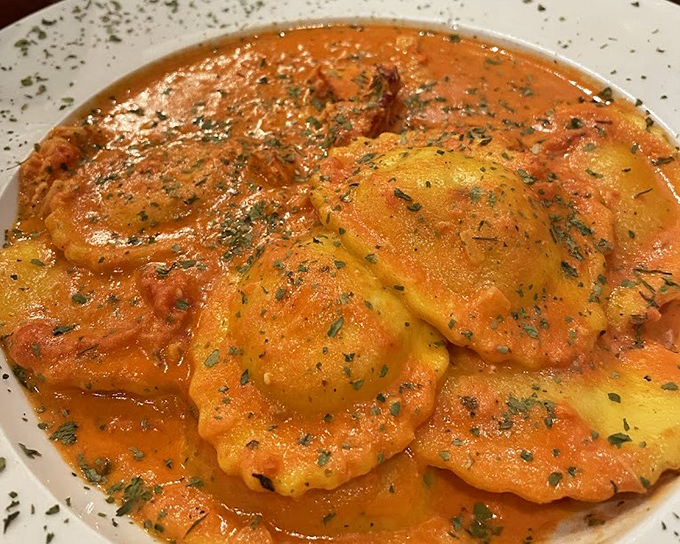 Lobster ravioli swimming in a sunset-colored sauce &ndash; pasta pillows filled with treasure from the deep, each bite a little celebration.