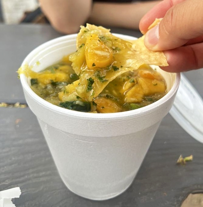 Green chile salsa in a cup, looking innocent but packing more heat than Arizona in August.