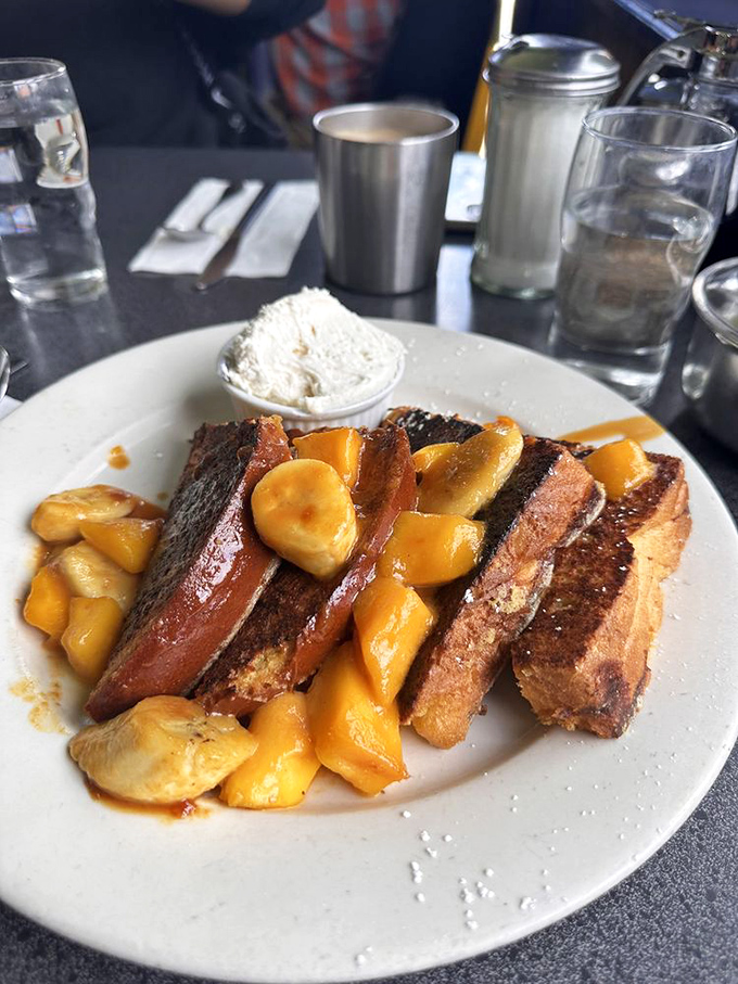 French toast that's having an identity crisis as bananas foster – caramelized fruit and thick-cut bread conspiring to make you forget all other breakfast options.