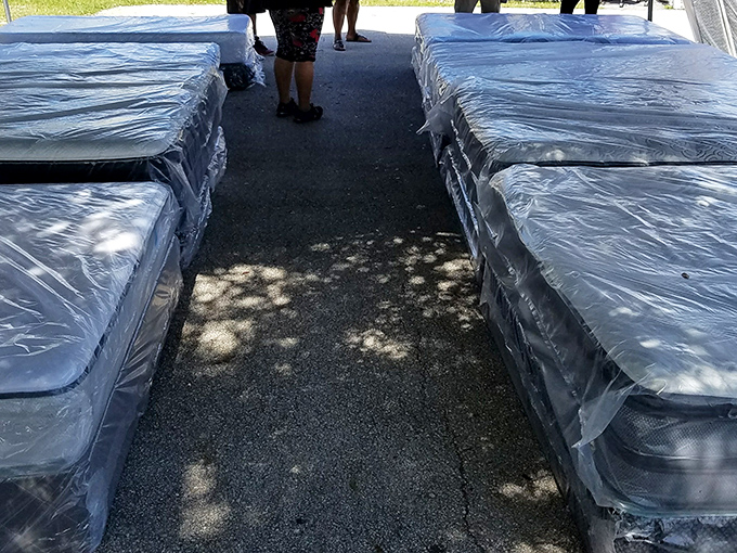 Mattress alley, where dreams come at discount prices. These still-wrapped sleep surfaces promise better nights without the showroom pressure tactics.