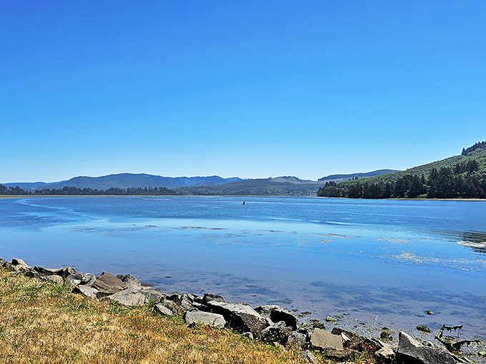 Nehalem Bay's tranquil waters reflect the surrounding mountains, creating a peaceful alternative to ocean waves just minutes from Manzanita's beaches.