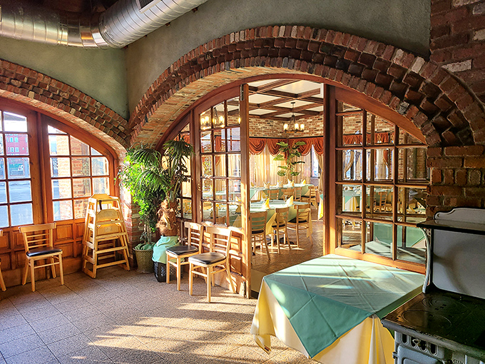 Sunlight streaming through arched doorways creates dining zones that feel both intimate and connected. Architecture that understands the importance of good lighting.