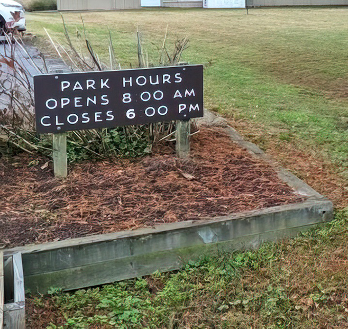 The park hours sign&mdash;nature's way of saying "we're open, but even wilderness needs some alone time." Early birds get the worms and the best morning light.