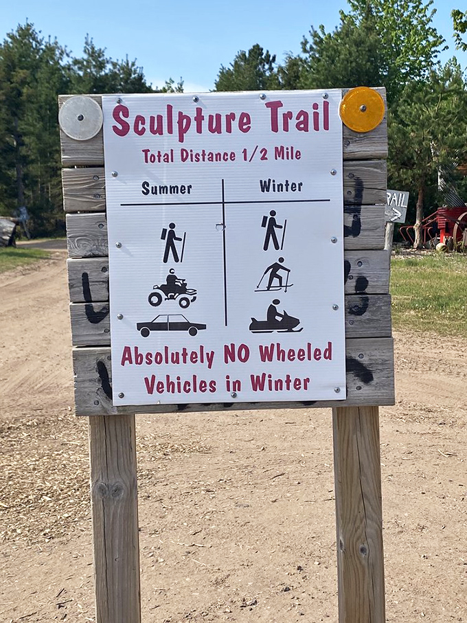 The sculpture trail sign lays down the law with a wink. Half a mile of wonder awaits, but leave your snowmobile at home during winter months.