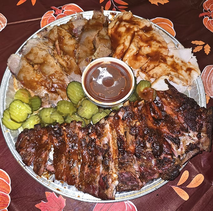 This isn't just a platter; it's a family reunion of meats, where ribs and sliced pork gather around a sauce cup centerpiece for a celebration of smoke.