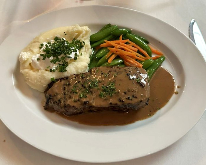 The pepper steak arrives bathed in a cognac sauce so good you'll consider drinking it straight when no one's looking.