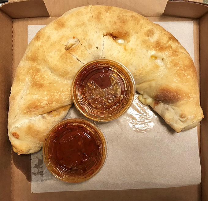 The calzone &ndash; pizza's mysterious, folded cousin. Two dipping sauces because important decisions shouldn't be made on an empty stomach.