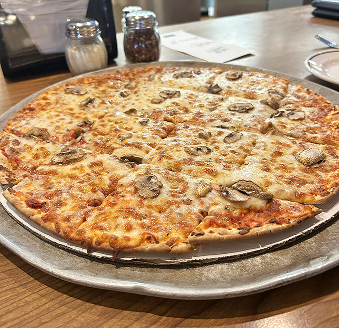 Pizza with mushrooms scattered like nature's confetti - sometimes the classics need no embellishment to shine bright.