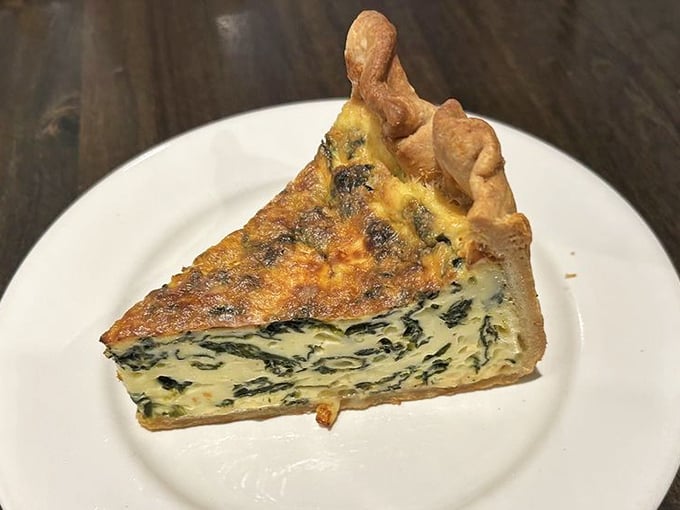 Flaky crust and savory spinach filling await you in this perfectly golden slice of quiche, making for a delicious meal.