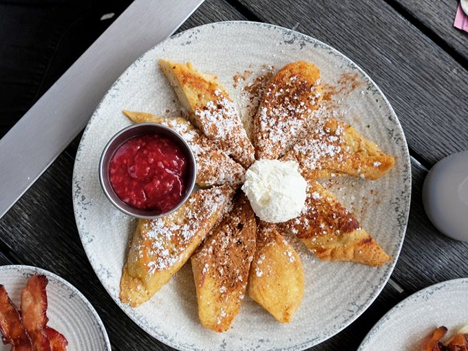 These French toast triangles, dusted with powdered sugar and served with bright raspberry compote, are breakfast masquerading as dessert.