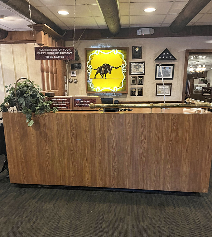 The reception desk, adorned with the glowing bull emblem, serves as command central for the nightly parade of hungry patrons.