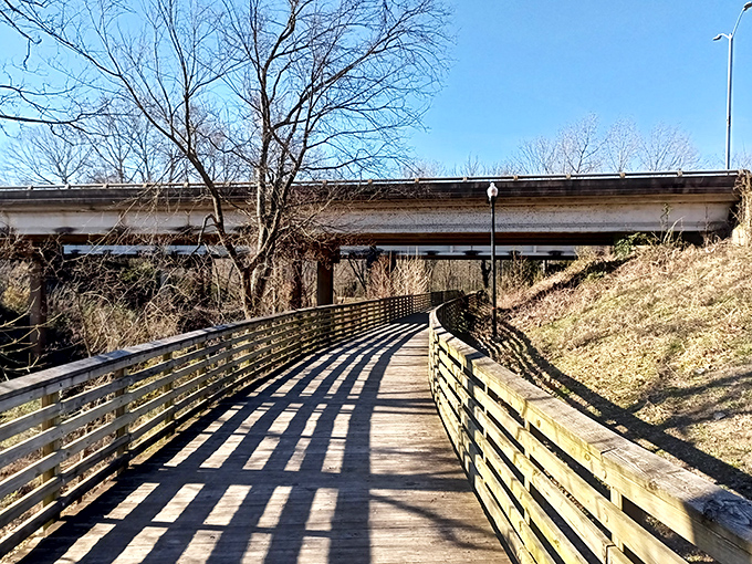 The Riverwalk's wooden pathway meanders beneath dappled sunlight, offering a peaceful retreat that costs nothing but time.