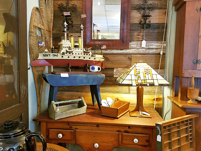 A model Navy ship from 1940 sails permanently atop a rustic table, while a Craftsman-style stained glass lamp stands ready to illuminate evening reading.