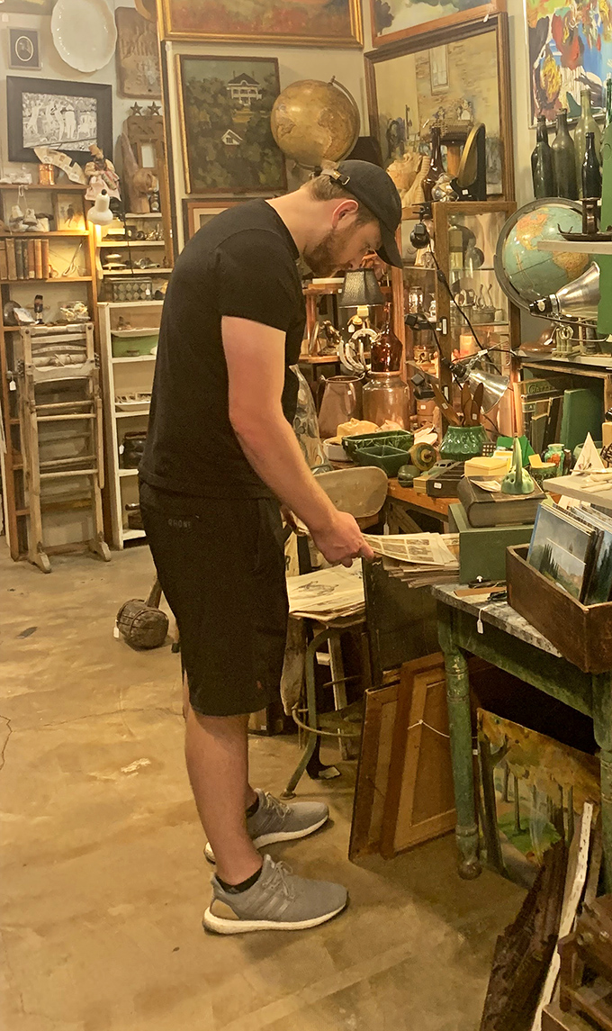 The modern treasure hunter at work. Notice the focused concentration&mdash;that's the face of someone who just spotted the perfect vintage find. 