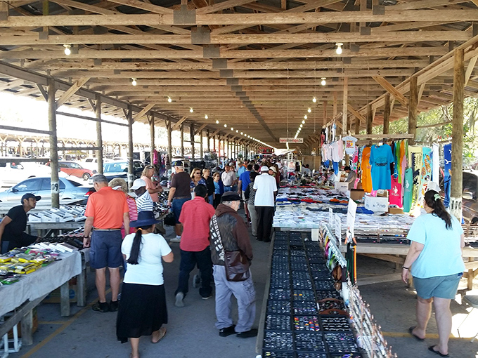 The covered pavilion hums with commerce as shoppers hunt for treasures among tables laden with possibilities and stories waiting to be discovered.