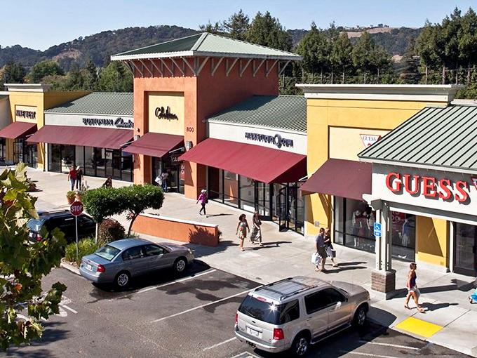 The colorful storefronts of Napa Premium Outlets create a retail village where shoppers stroll between Calvin Klein and Guess as if window shopping on a European vacation.
