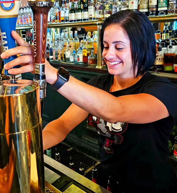 The art of the perfect pour requires skill and patience – this bartender's smile suggests she's mastered both while keeping glasses full and spirits high.