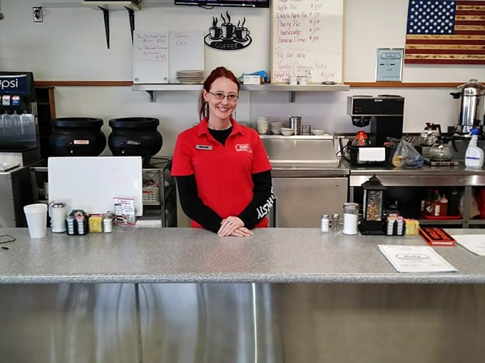 A friendly face behind the counter, ready to keep your coffee cup filled and your spirits high. The red uniform matches the building's exterior.
