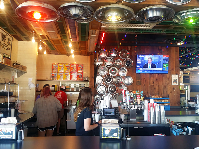 Behind the counter, where burger magic happens, vintage hubcaps create a backdrop that's equal parts automotive museum and culinary workshop.