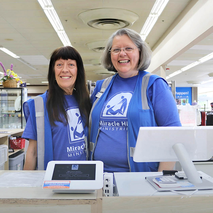The friendly faces behind the mission—staff members wearing bright blue Miracle Hill vests represent the heart of this community-focused organization.