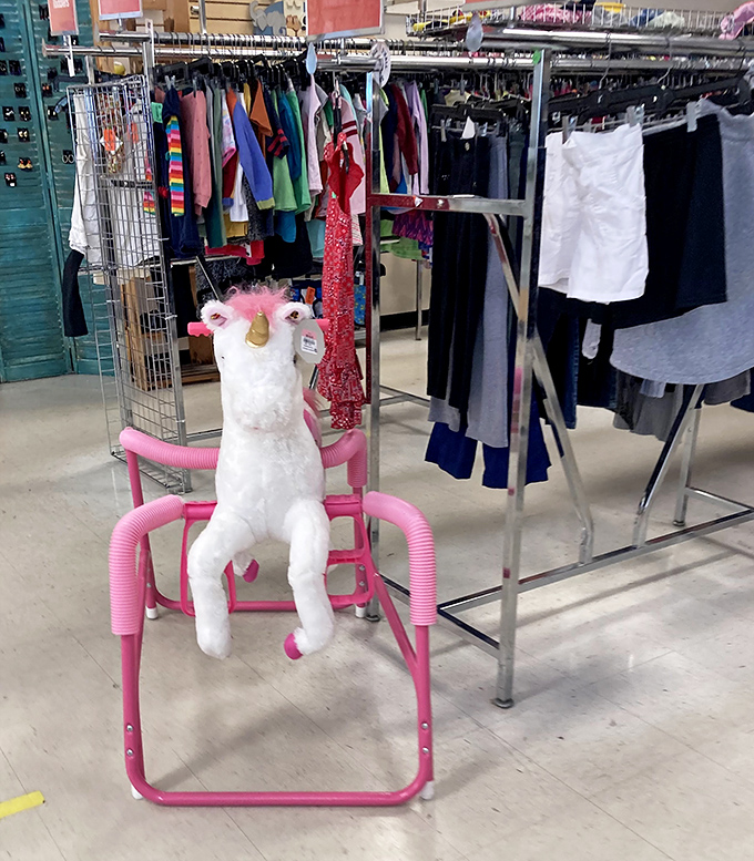 A mythical unicorn taking a rest on a pink chair, perfectly embodying the unexpected magic that makes thrift store hunting so addictive.