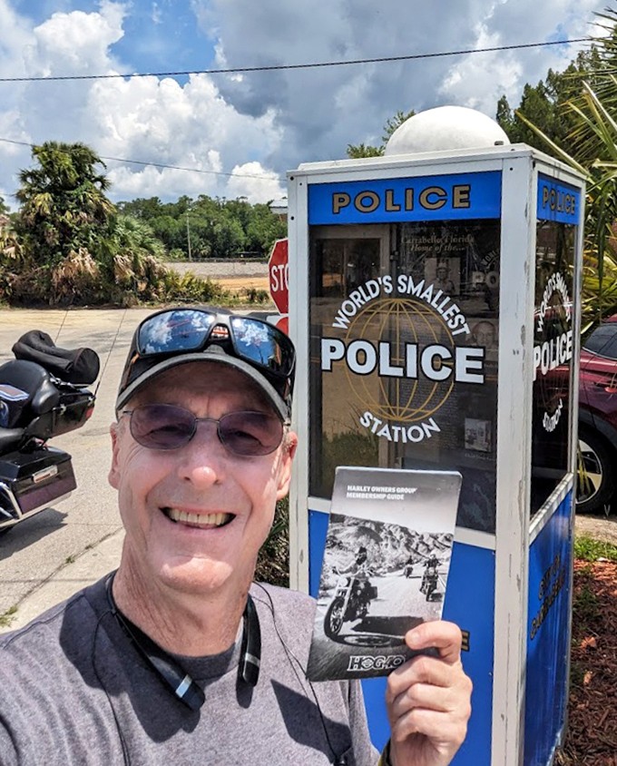 Souvenirs in hand, happy tourists capture proof they've visited this legendary law enforcement landmark. Case closed on vacation memories!