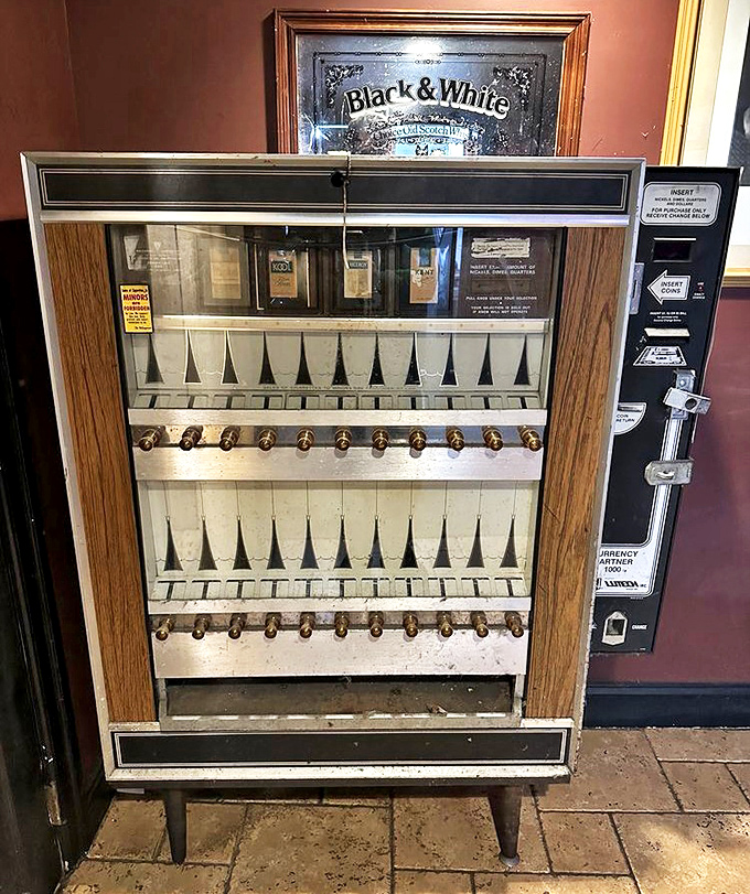 This vintage cigarette machine stands as a charming relic of bygone days, now just watching as new tavern traditions take shape.